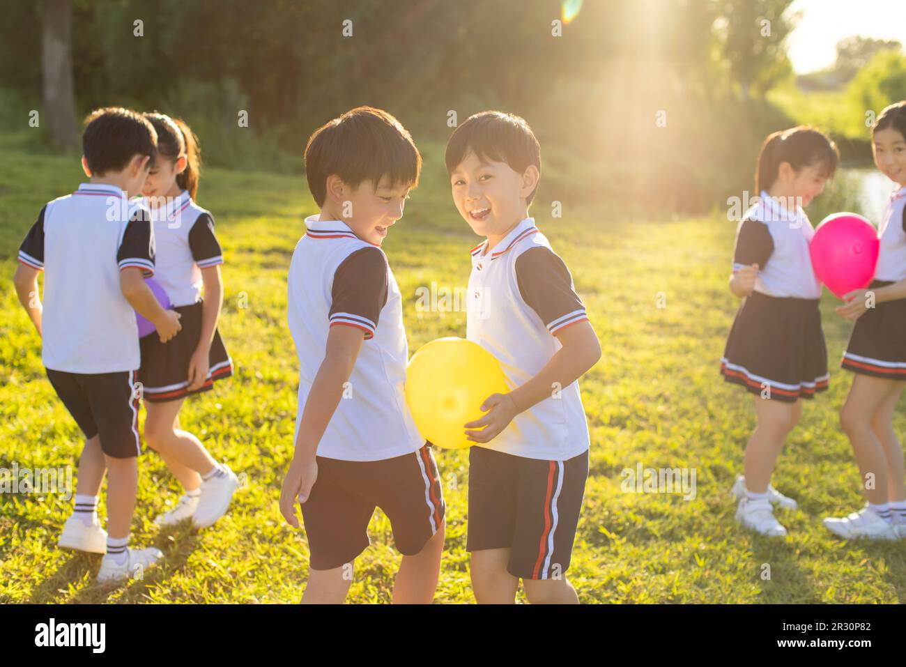 Cheerful Chinese school children playing in park Stock Photo - Alamy