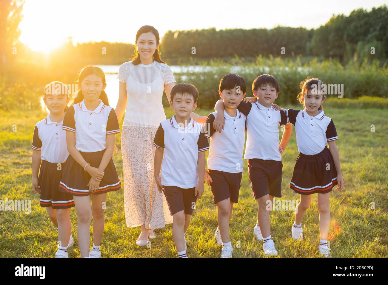 Cheerful Chinese school children relaxing in park with their teacher Stock Photo - Alamy