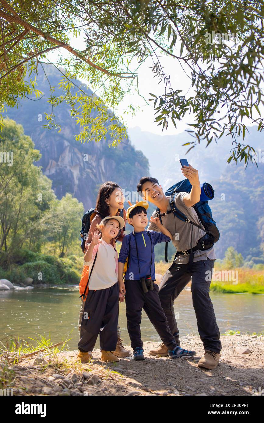 Happy young Chinese family hiking outdoors Stock Photo - Alamy