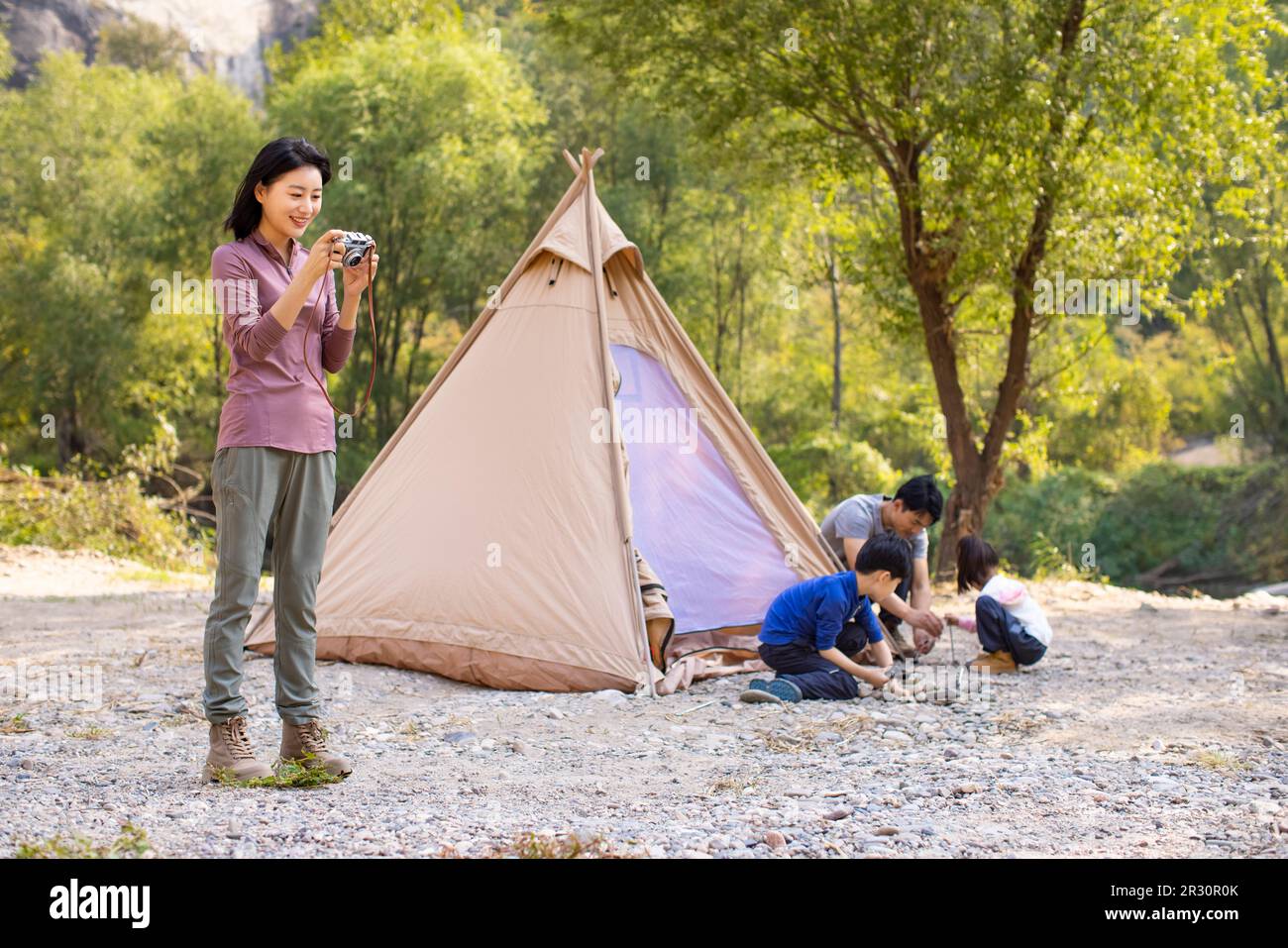 Happy young Chinese family camping outdoors Stock Photo - Alamy