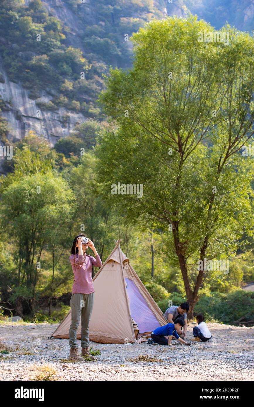 Happy young Chinese family camping outdoors Stock Photo - Alamy