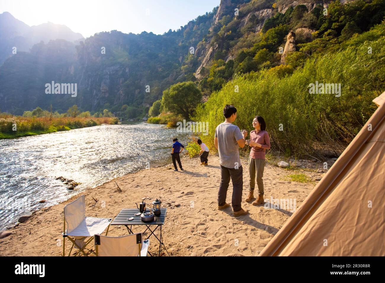 Happy young Chinese family camping outdoors Stock Photo - Alamy