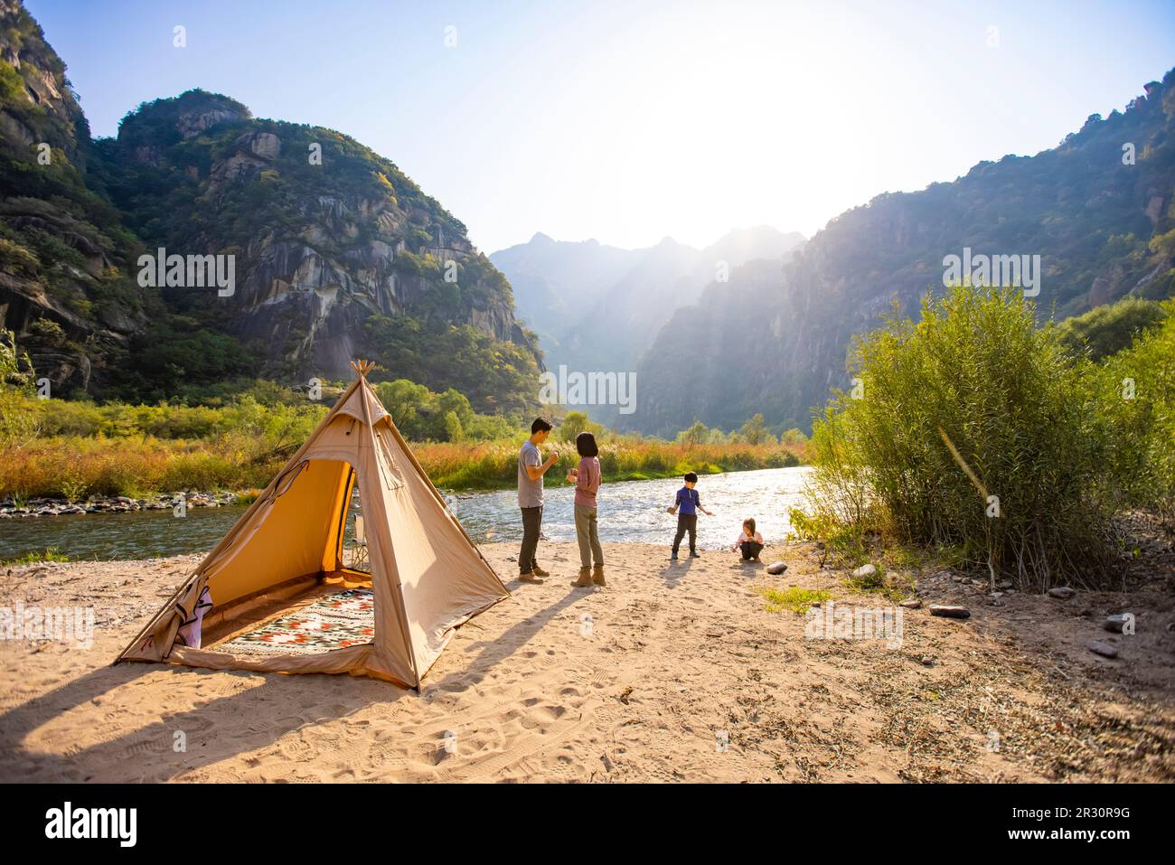 Happy young Chinese family camping outdoors Stock Photo - Alamy