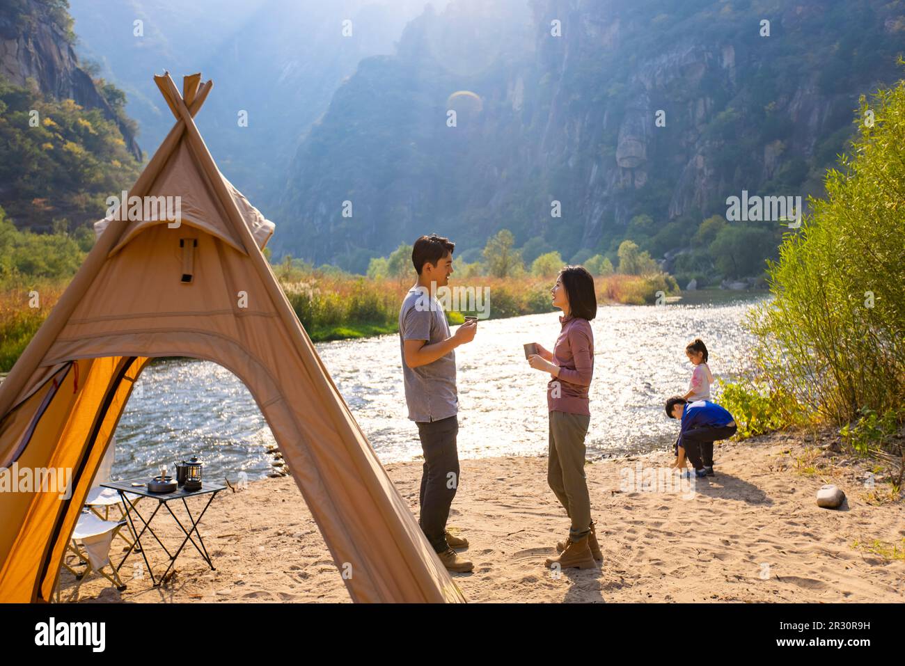 Happy young Chinese family camping outdoors Stock Photo - Alamy