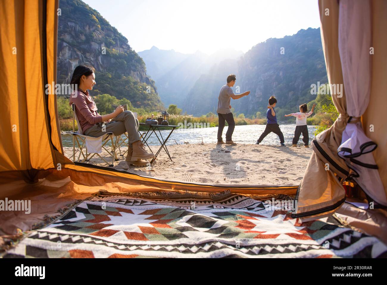 Happy young Chinese family camping outdoors Stock Photo - Alamy