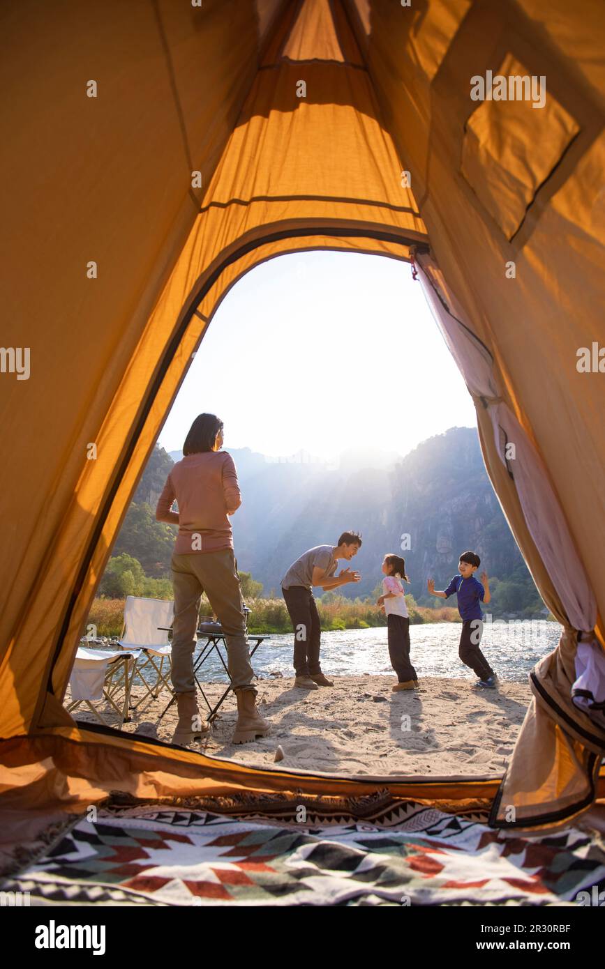Happy young Chinese family camping outdoors Stock Photo - Alamy