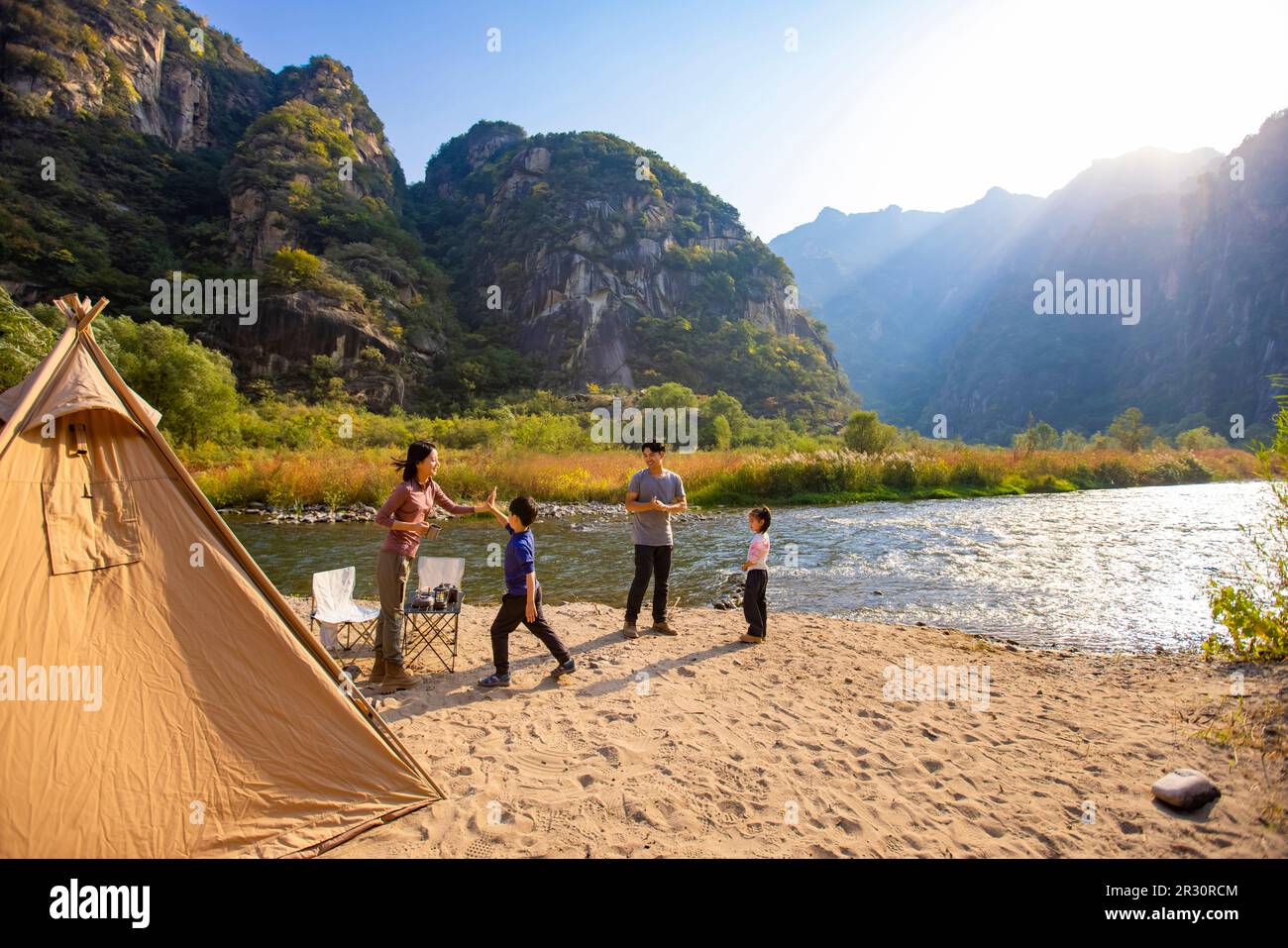 Happy young Chinese family camping outdoors Stock Photo - Alamy