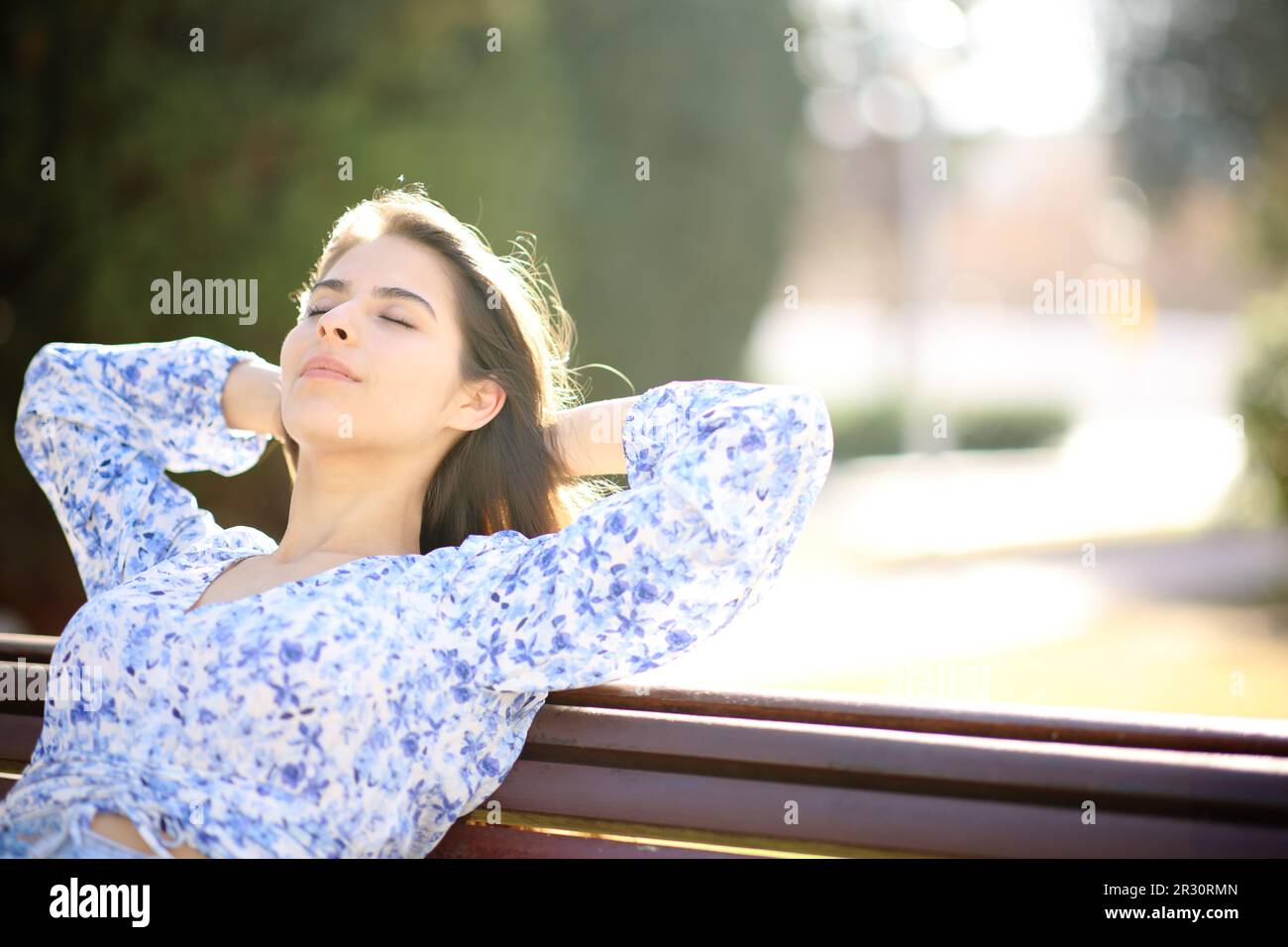 Woman relaxing and resting sitting in a bench in a park Stock Photo - Alamy