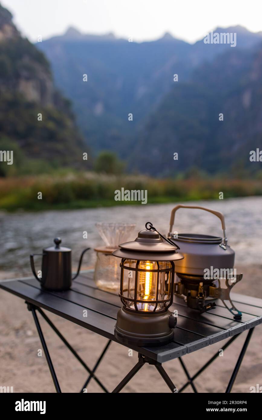 Lamp and kettle on picnic table Stock Photo - Alamy
