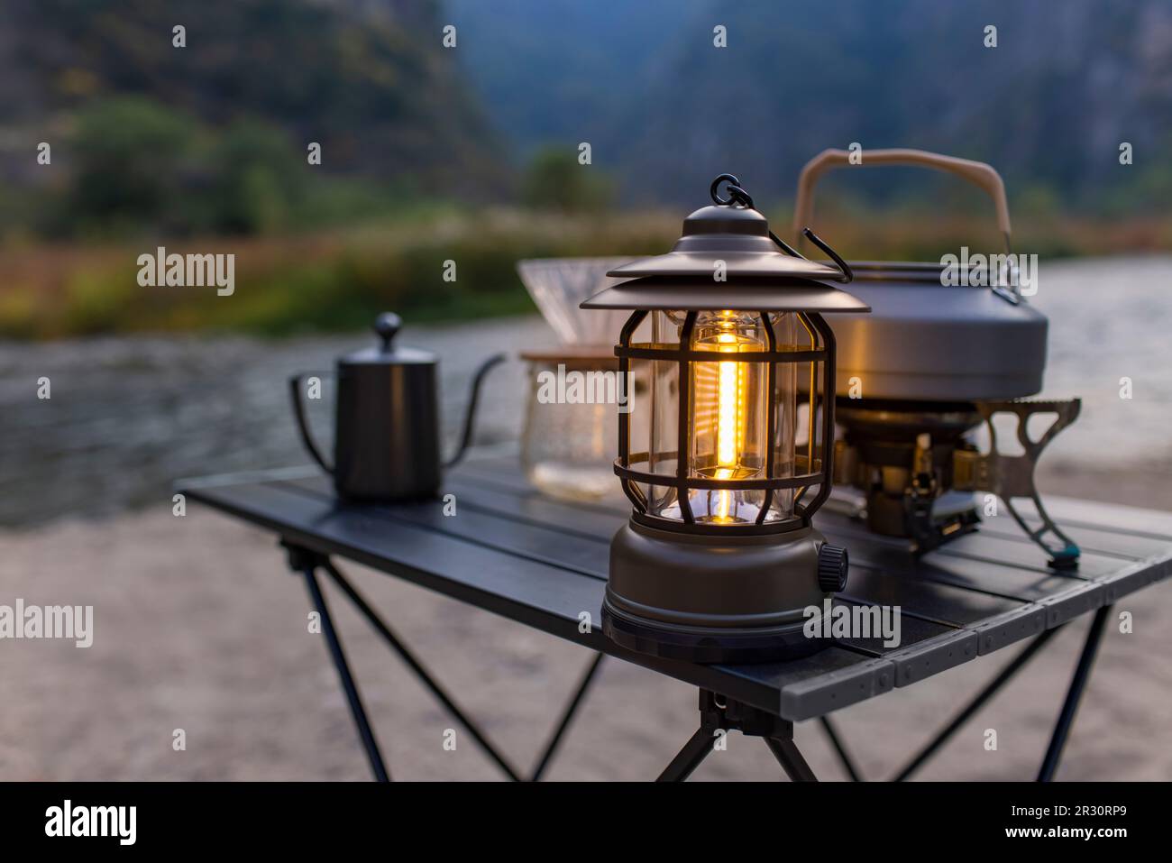 Lamp and kettle on picnic table Stock Photo - Alamy