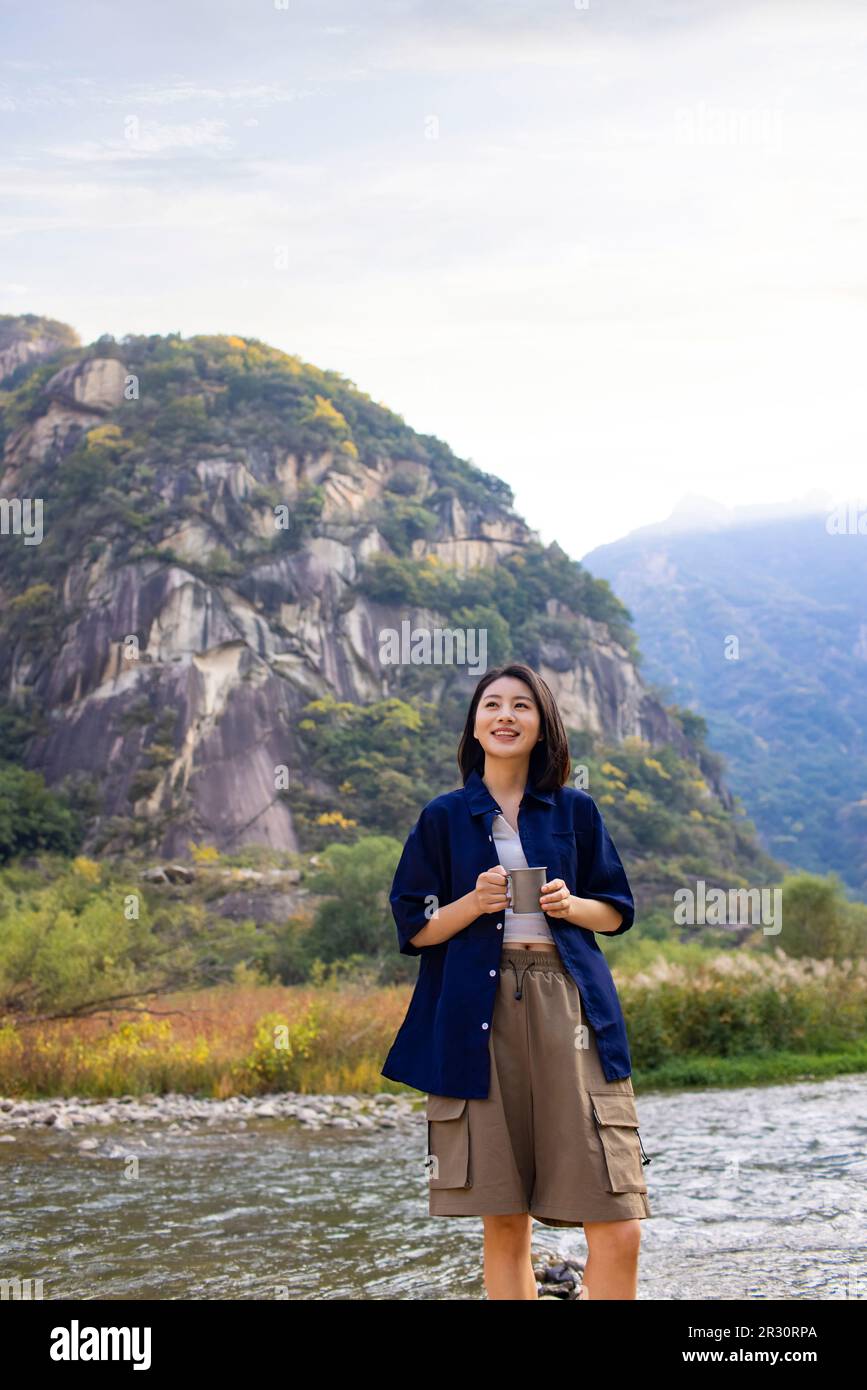 Cheerful young Chinese woman enjoying the beautiful natural scenery ...