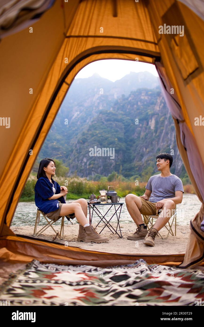 Happy young Chinese couple camping outdoors Stock Photo - Alamy