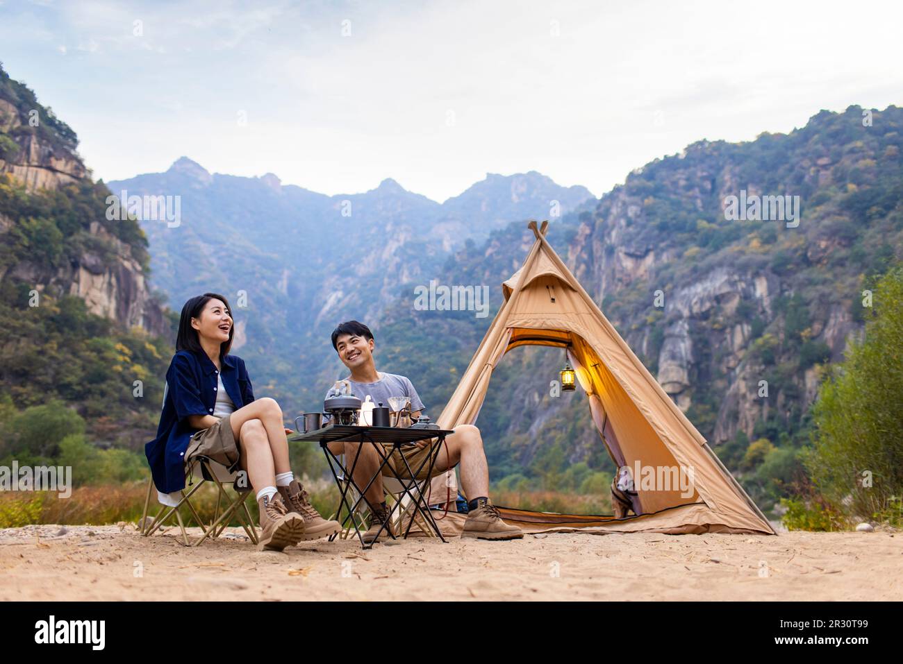 Happy young Chinese couple camping outdoors Stock Photo - Alamy
