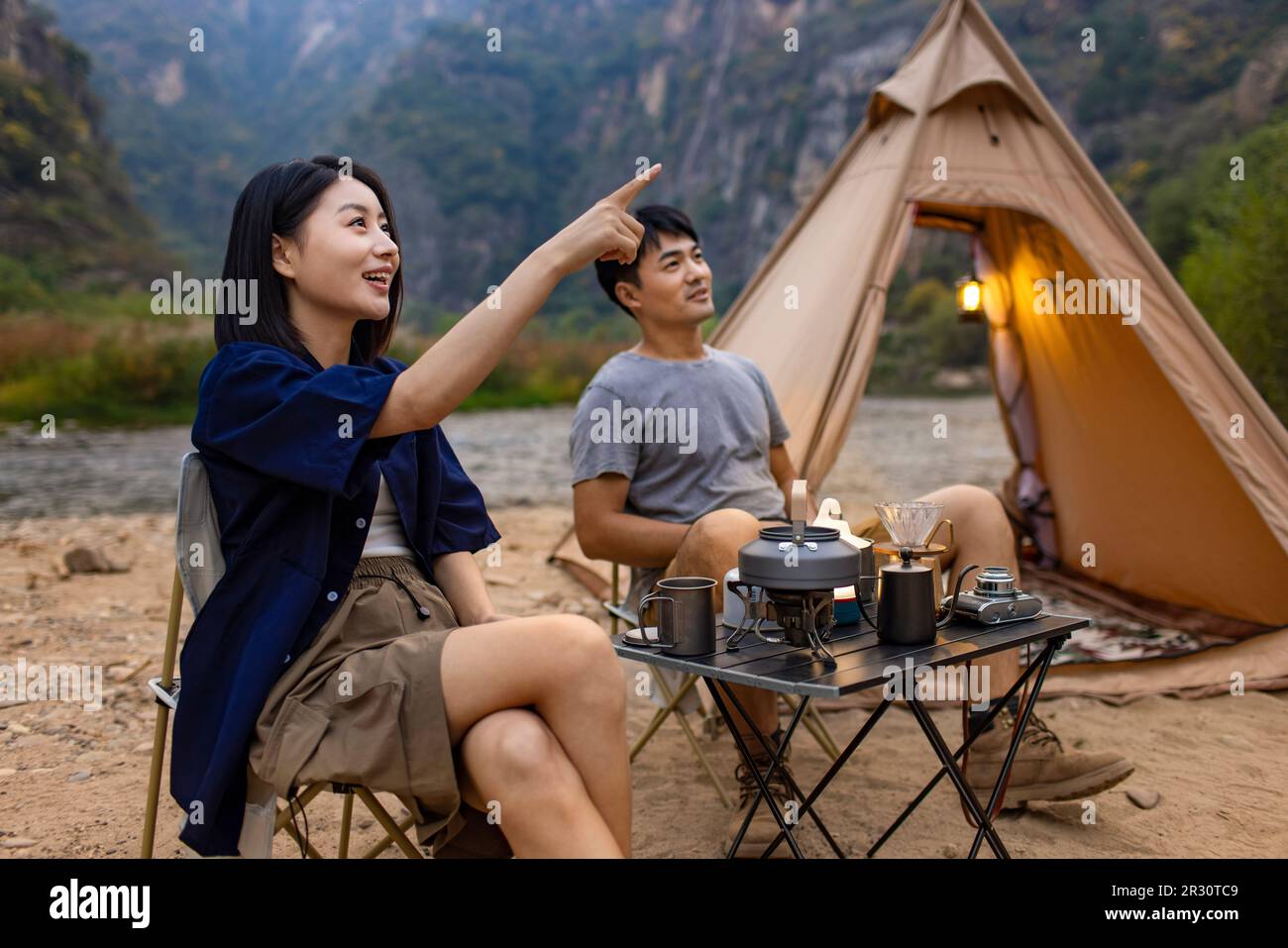 Happy young Chinese couple camping outdoors Stock Photo - Alamy