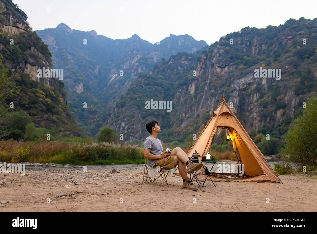 Young Chinese man camping outdoors Stock Photo - Alamy