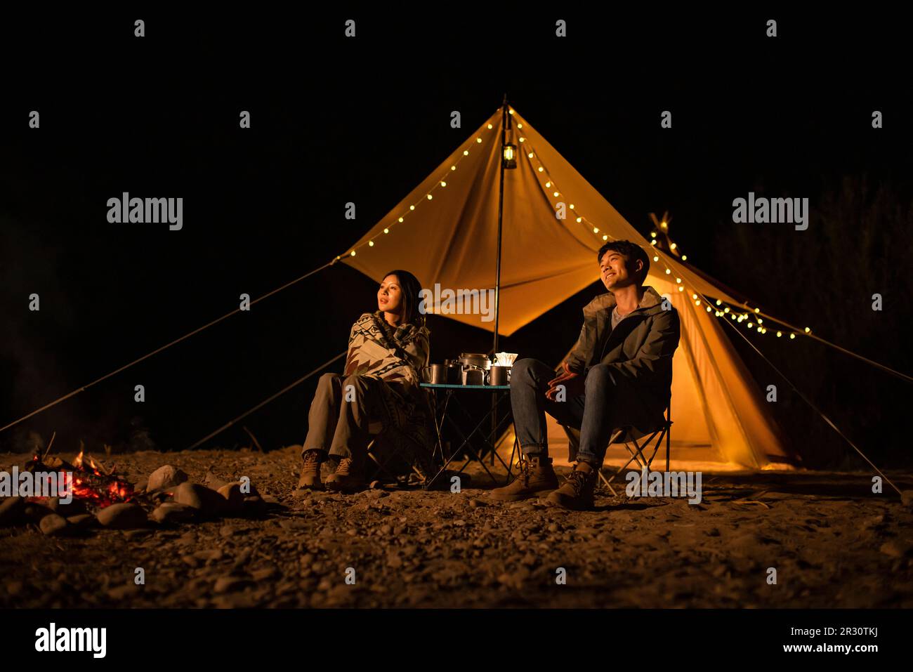 Happy young Chinese couple camping outdoors Stock Photo - Alamy
