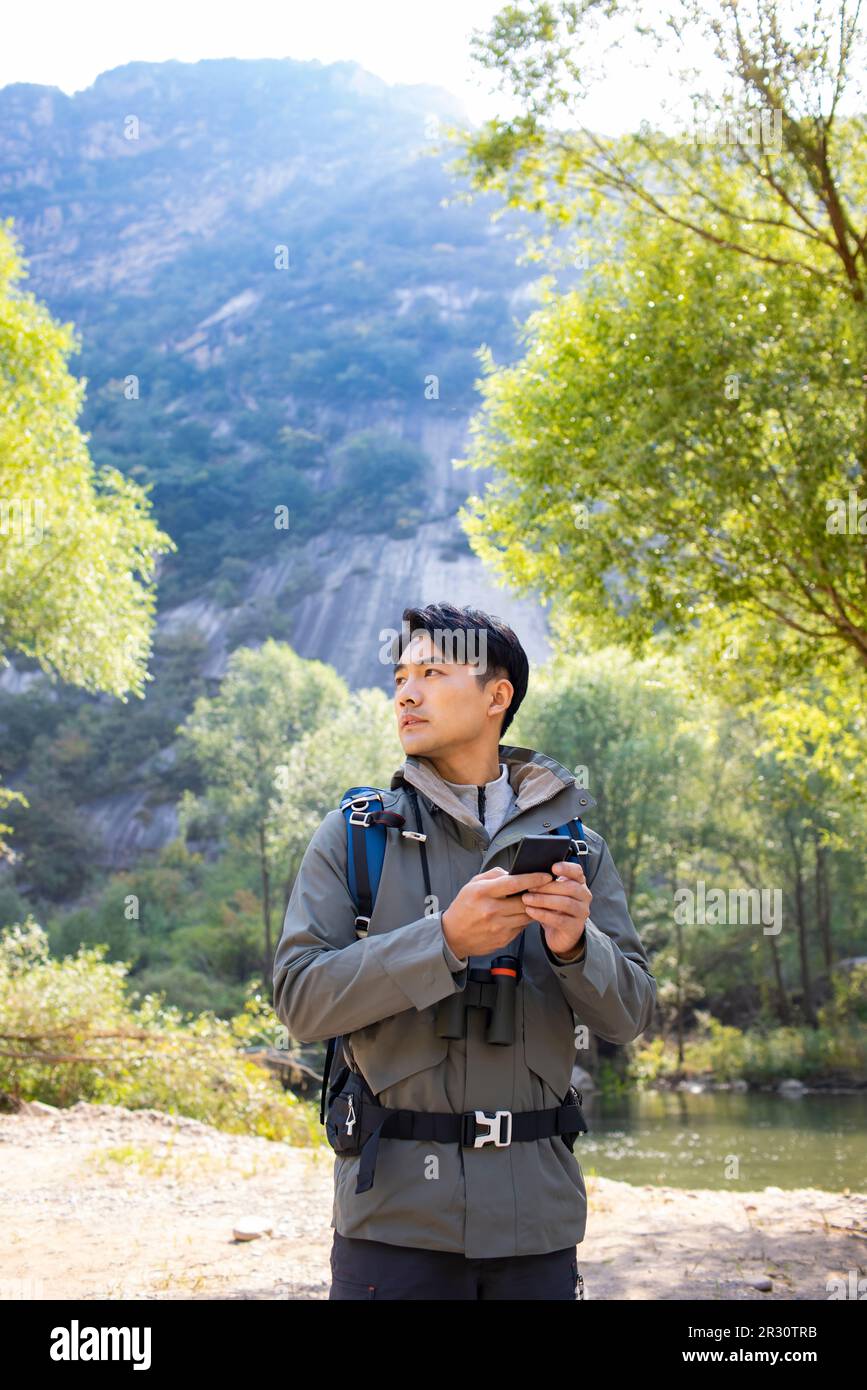 Young Chinese man hiking outdoors Stock Photo - Alamy