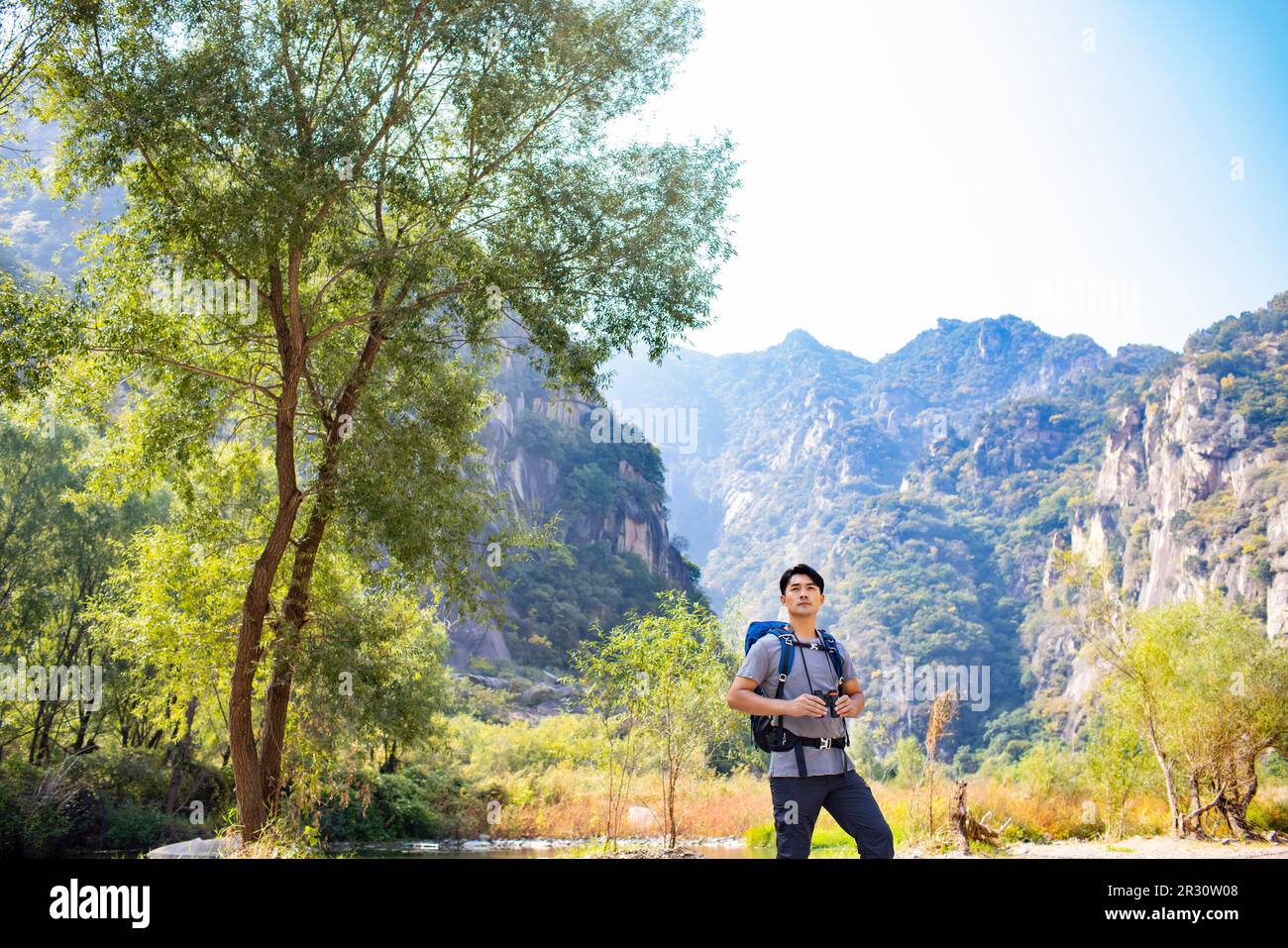 Young Chinese man hiking outdoors Stock Photo - Alamy