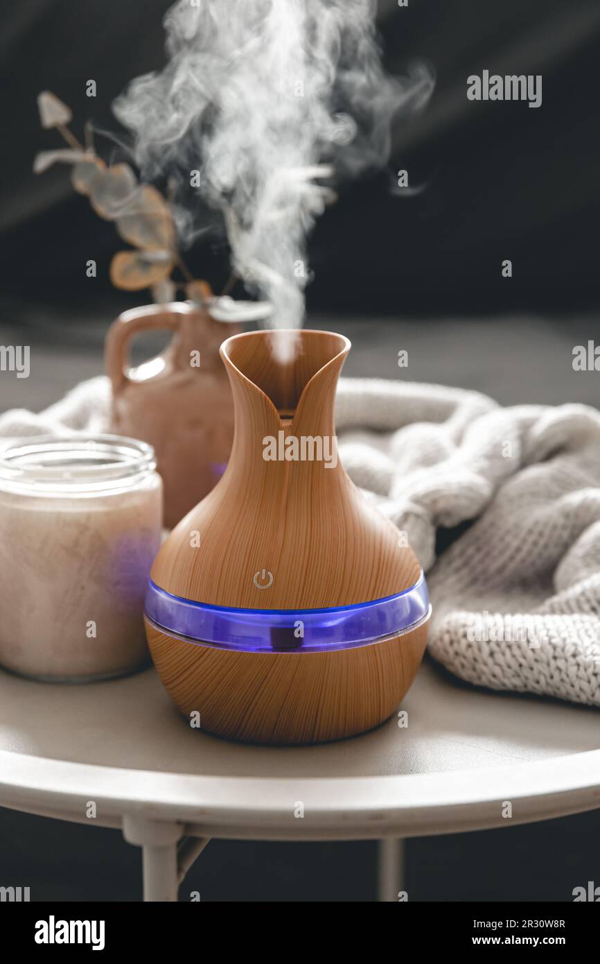 Spa composition with aroma oil diffuser lamp and candle on a blurred ...