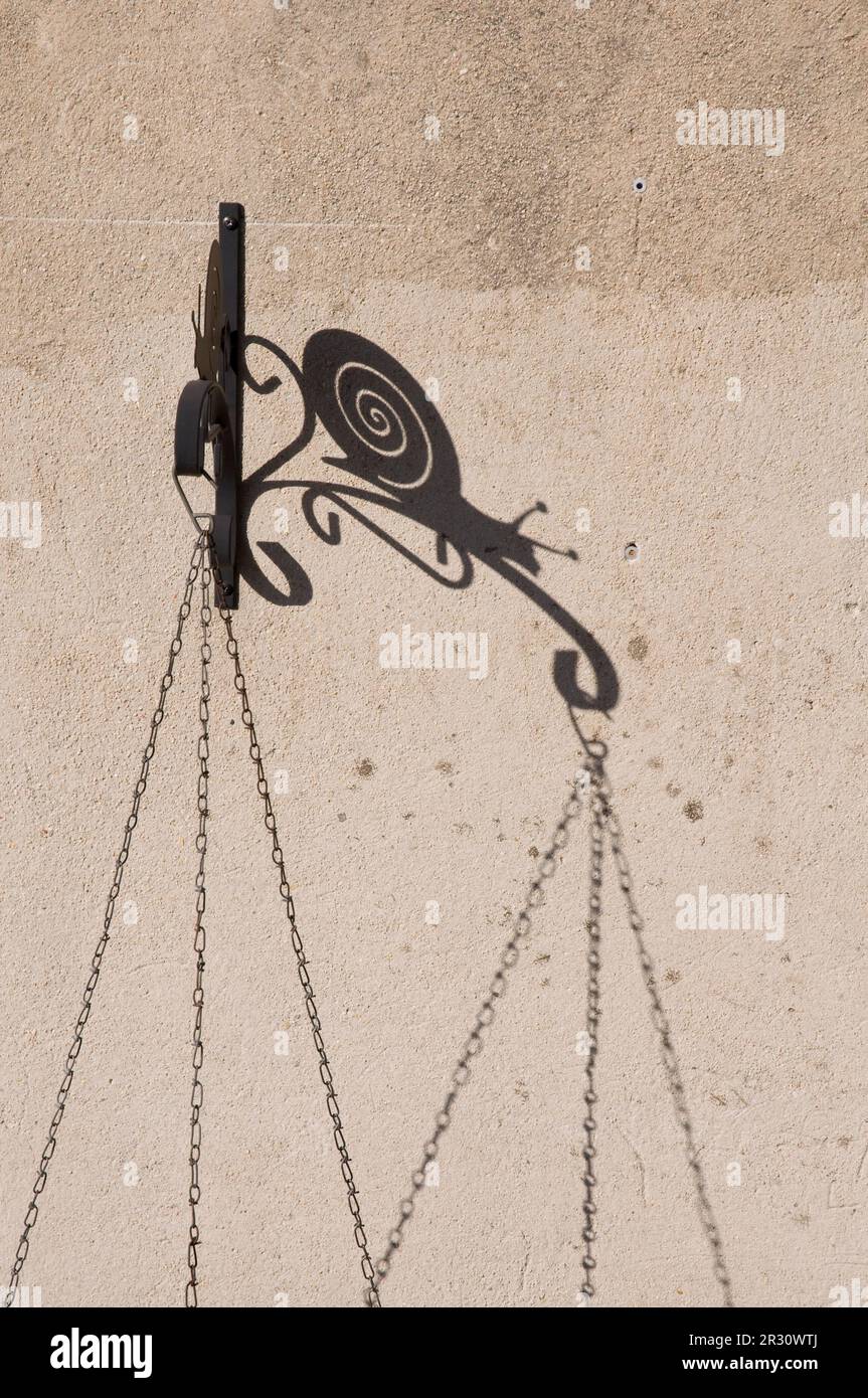 Shadow cast on a wall from a metal snail Stock Photo - Alamy
