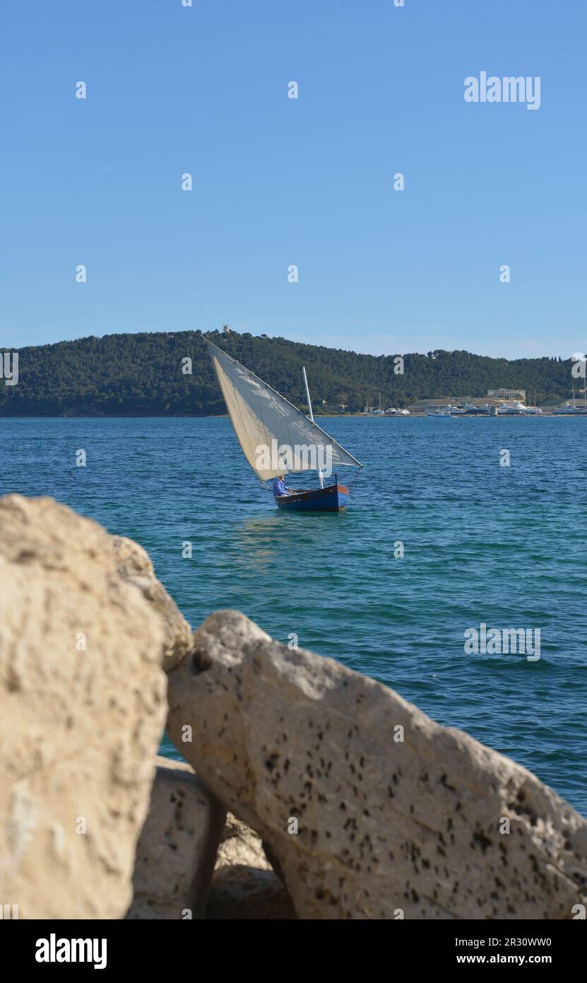Traditional Provencal boat entering under sail at the small port of St ...