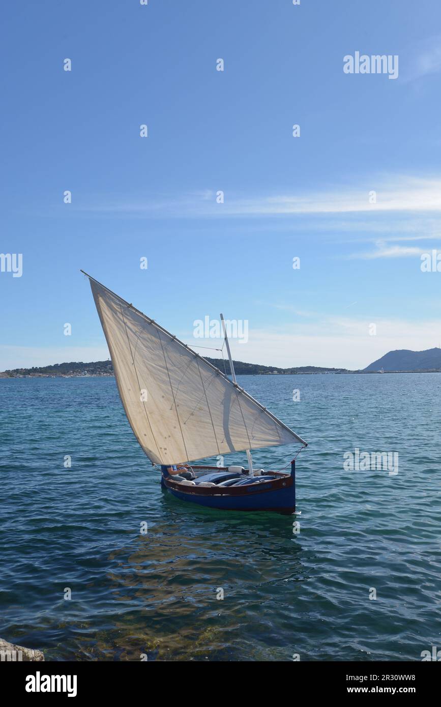 Traditional Provencal boat entering under sail at the small port of St ...
