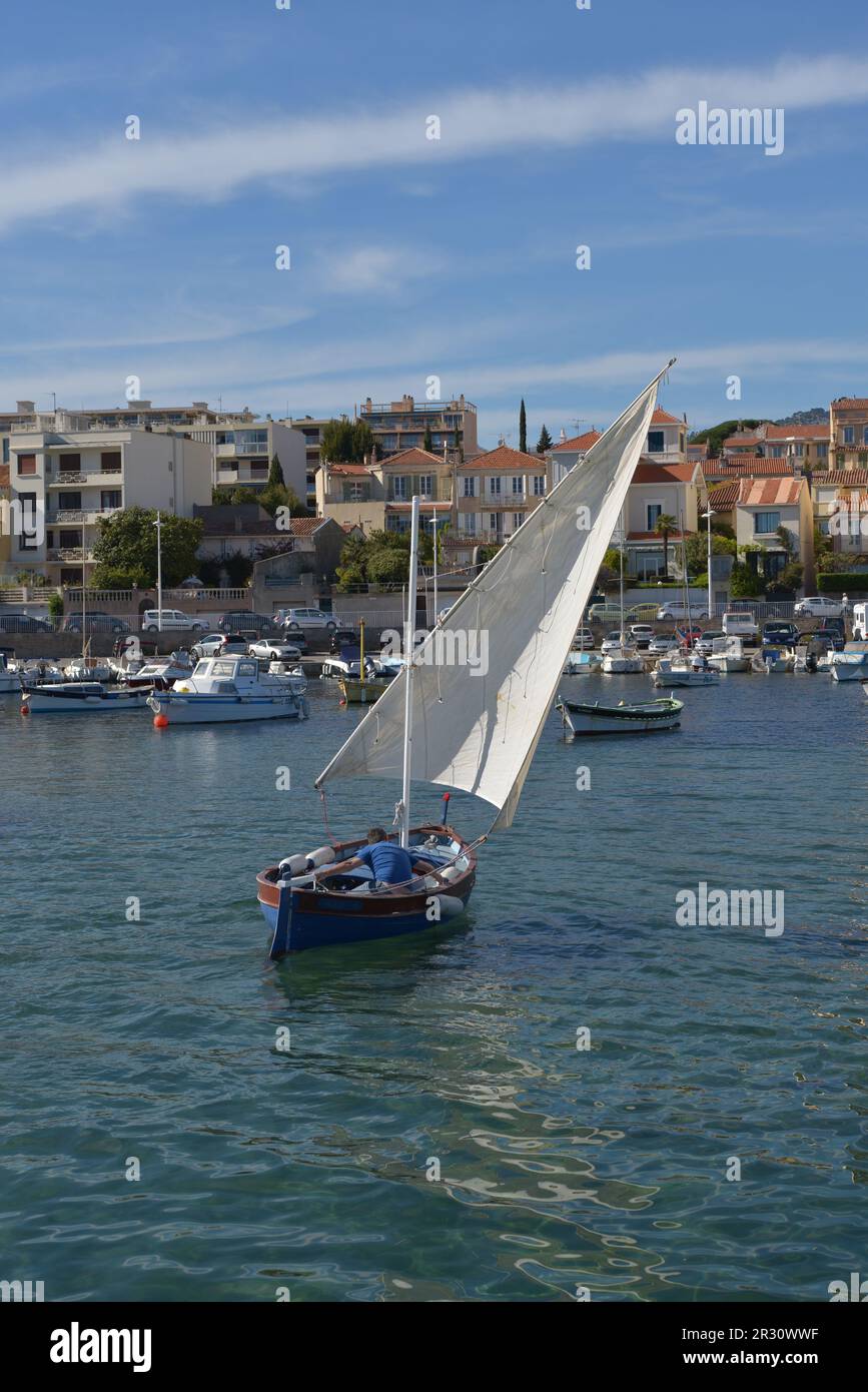Traditional Provencal boat entering under sail at the small port of St ...