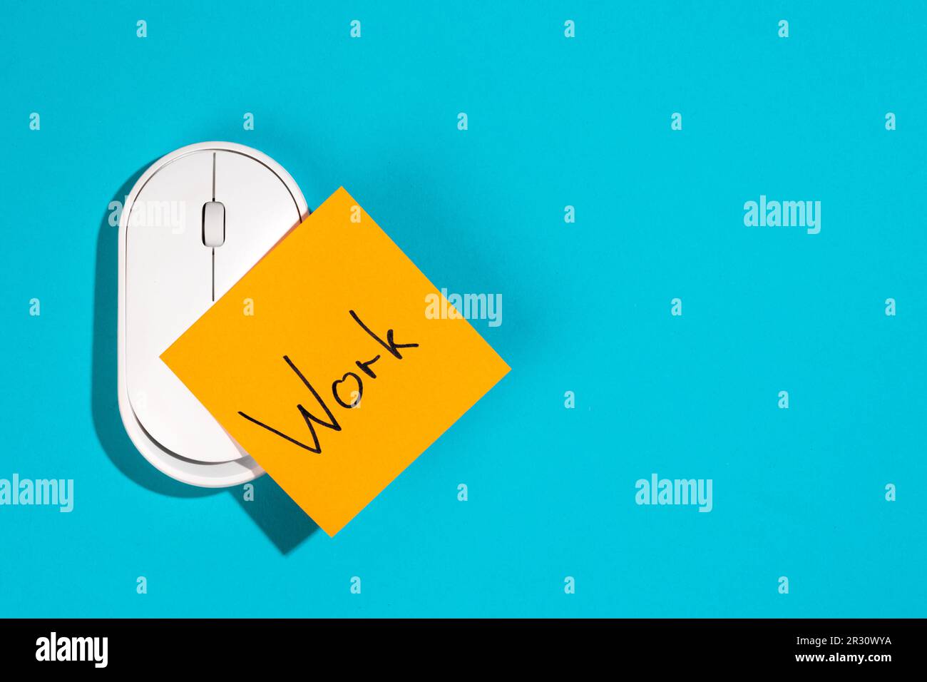 Computer mouse and reminder paper with the word work on a blue ...