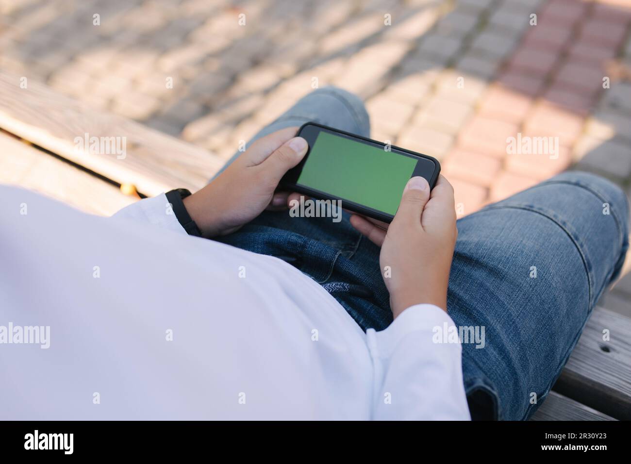 Mock up of boy play games on the smartphone. Bay hold phone ...