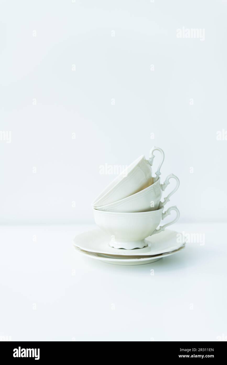 A set of cream porcelain cups with saucers on the table, preparation ...