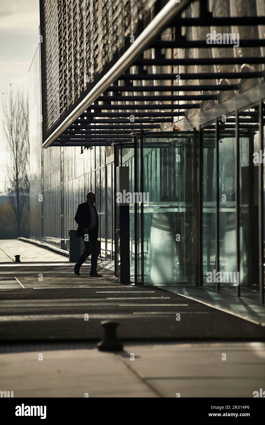 Office worker wearing a suit entering modern office building Stock ...