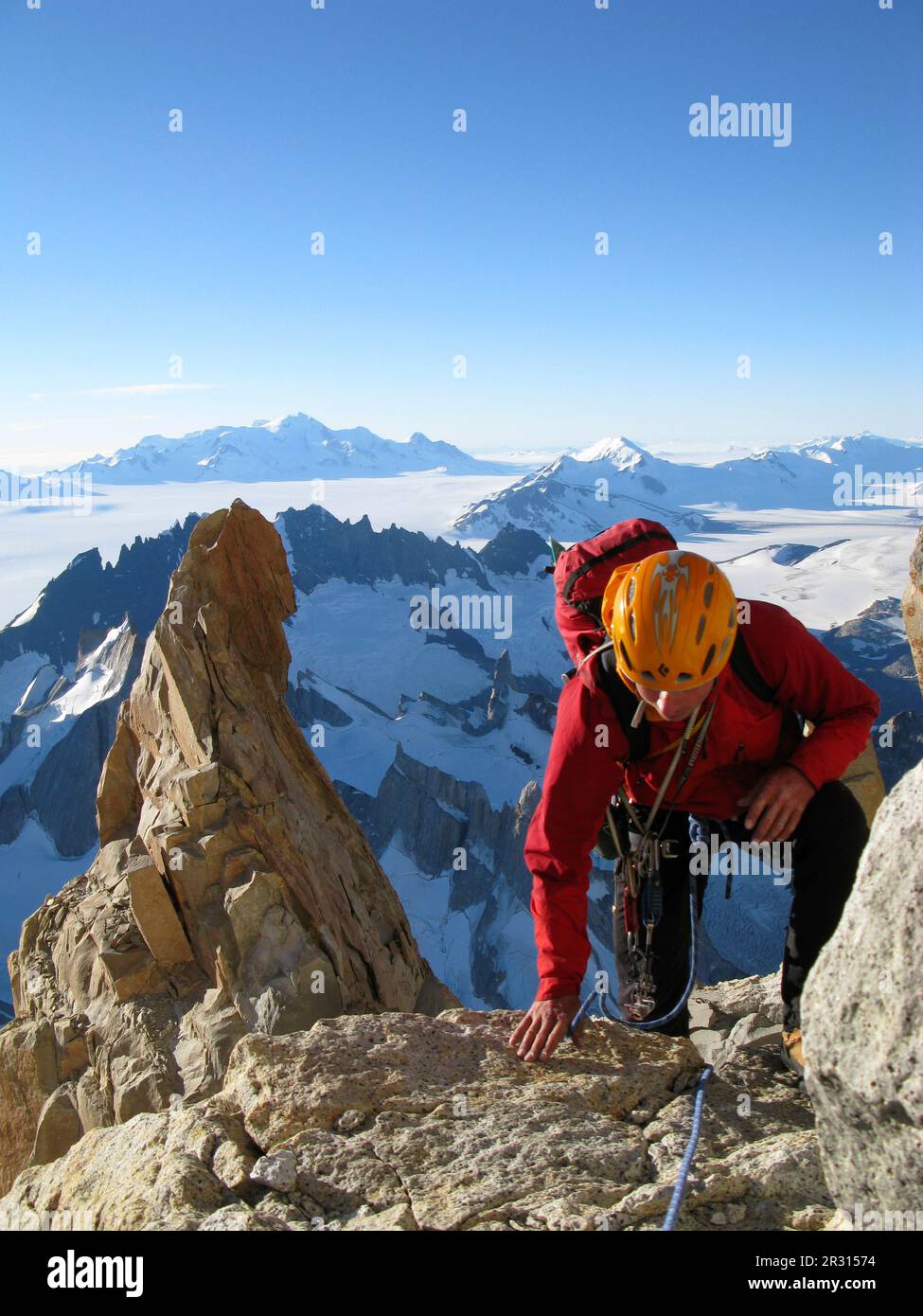A climber climbs on the northwest ridge of Cerro Fitz Roy, with Volcan ...