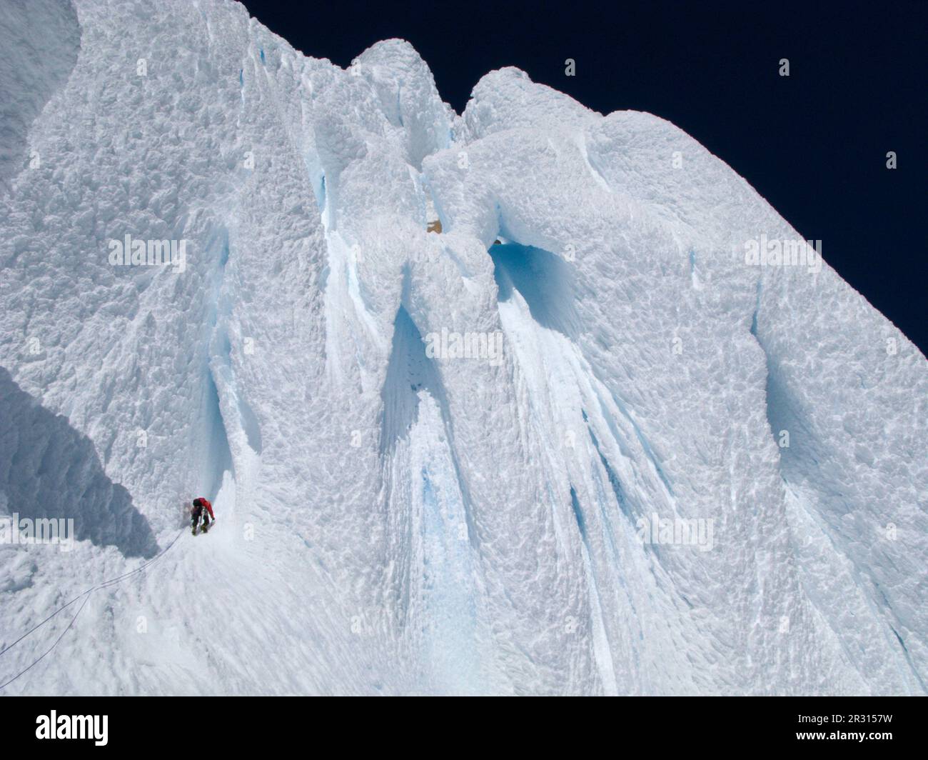 An alpinist climbs a snow "mushroom", crowning the summit of Cerro Torre's west ridge, during ...