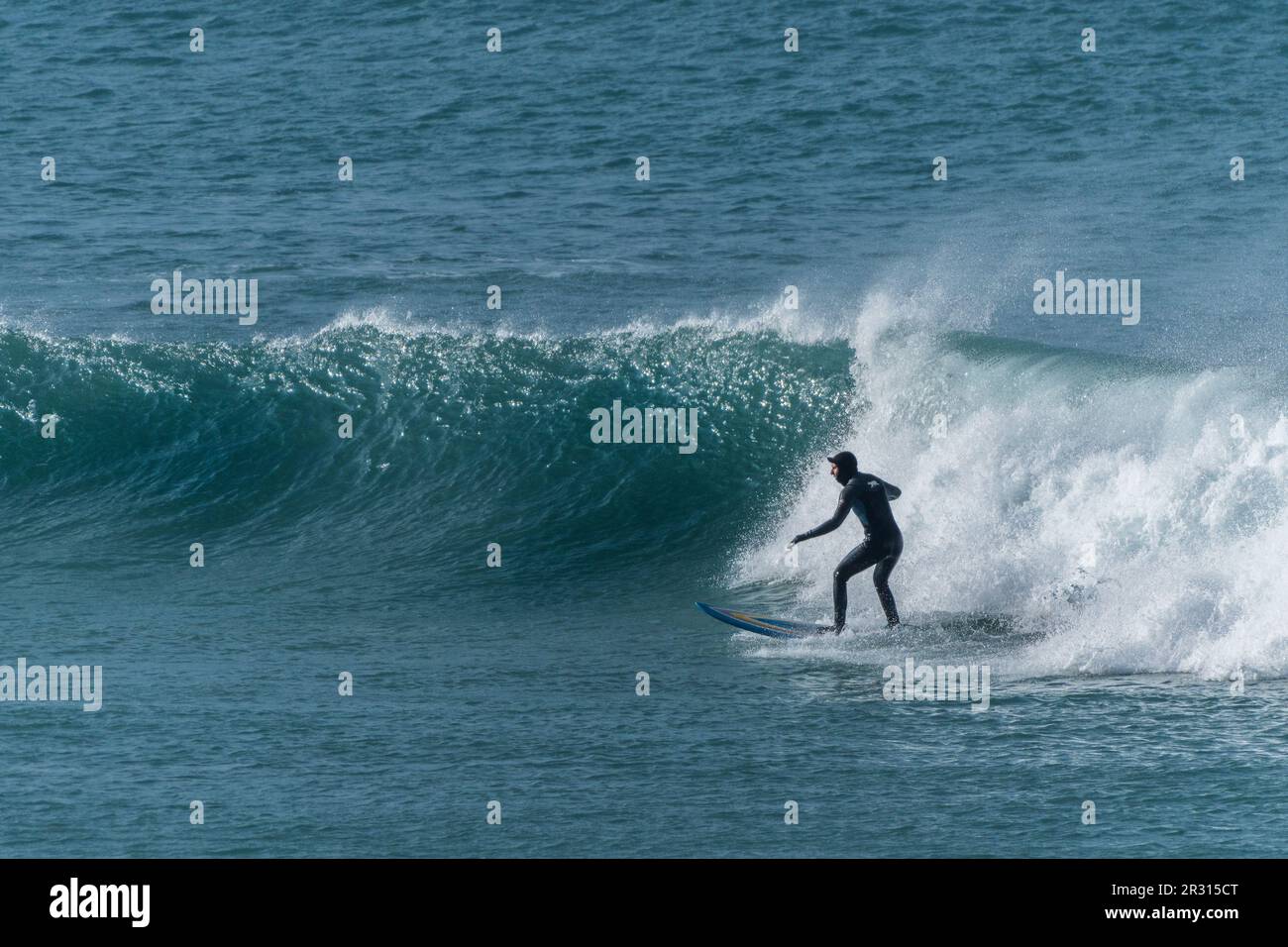 A lone surfer riding a large wave at Fistral in Newquay in Cornwall in ...