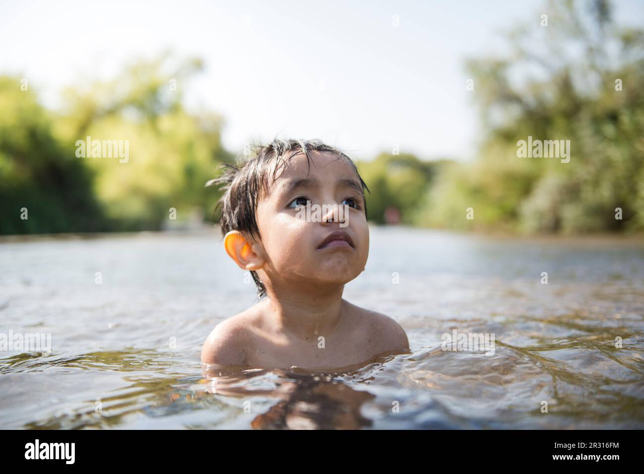 Latin child in peace enjoying summer in a river Stock Photo - Alamy