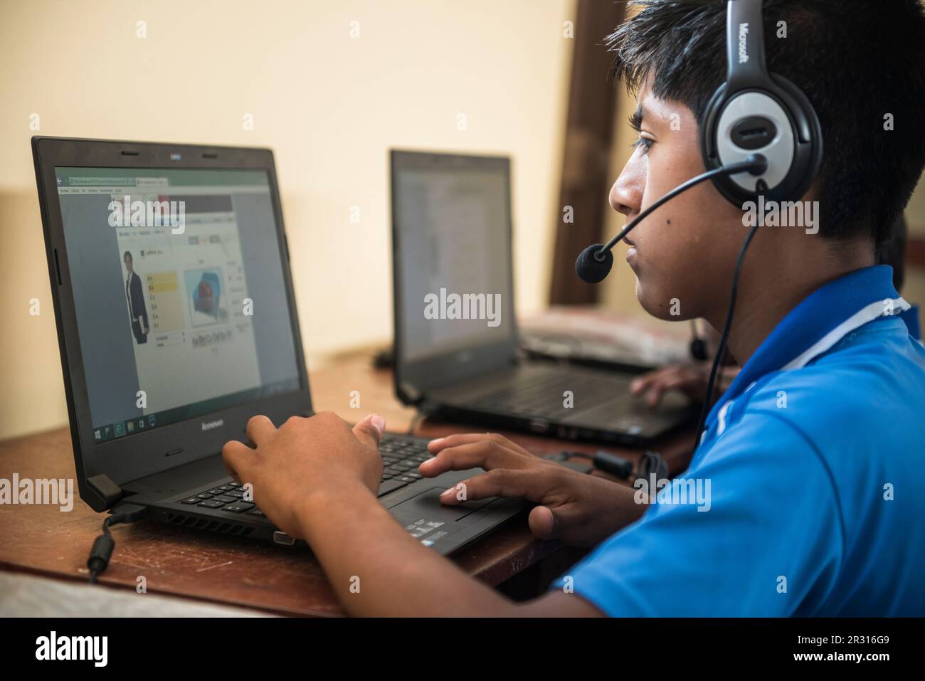Peruvian boy learning English using computers in a classroom Stock ...