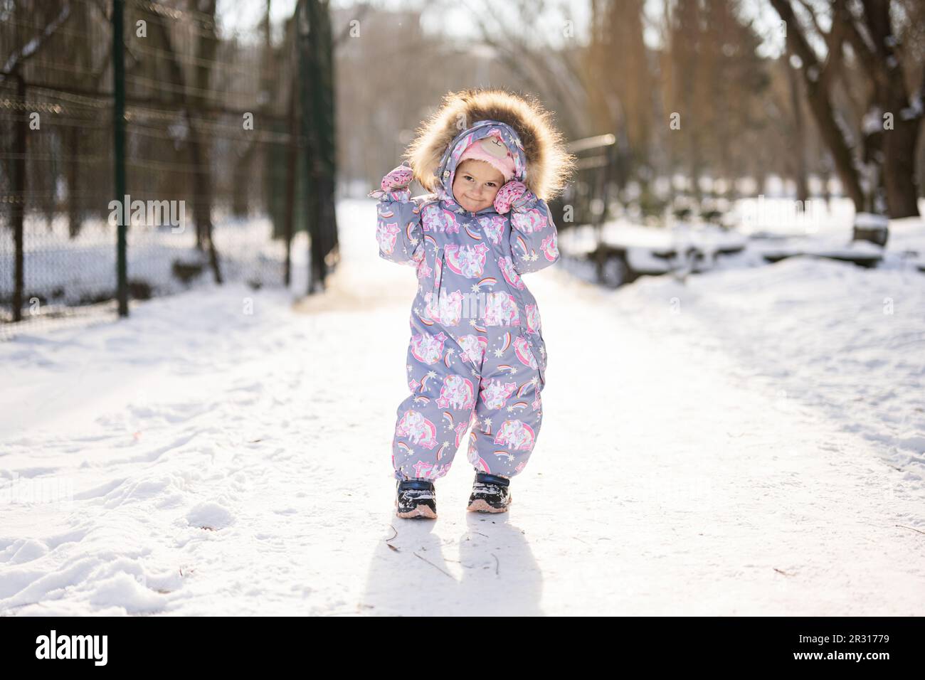 Baby girl wear child snowsuit on a sunny frosty winter day Stock Photo ...