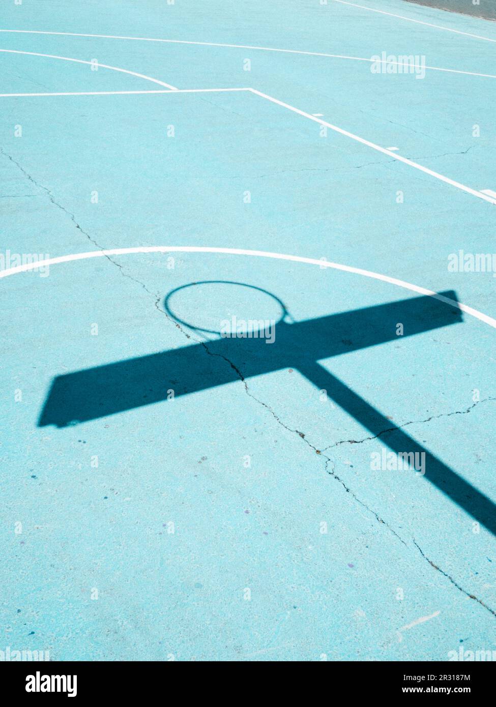 Basketball hoop shadow and white lines on blue court surface Stock ...