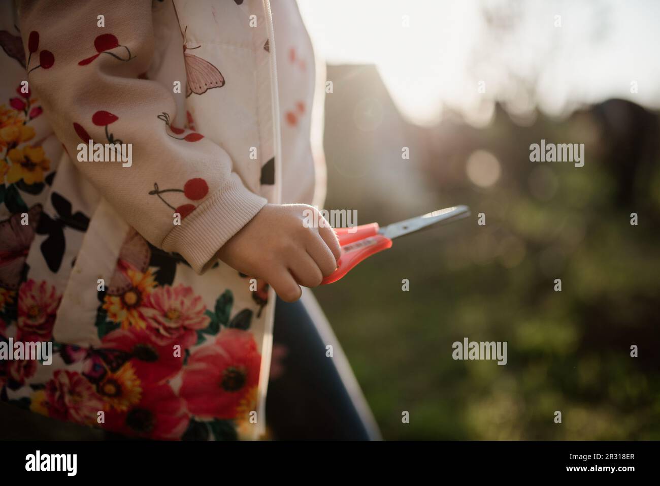 Little girl holidng a scissors in nature Stock Photo - Alamy