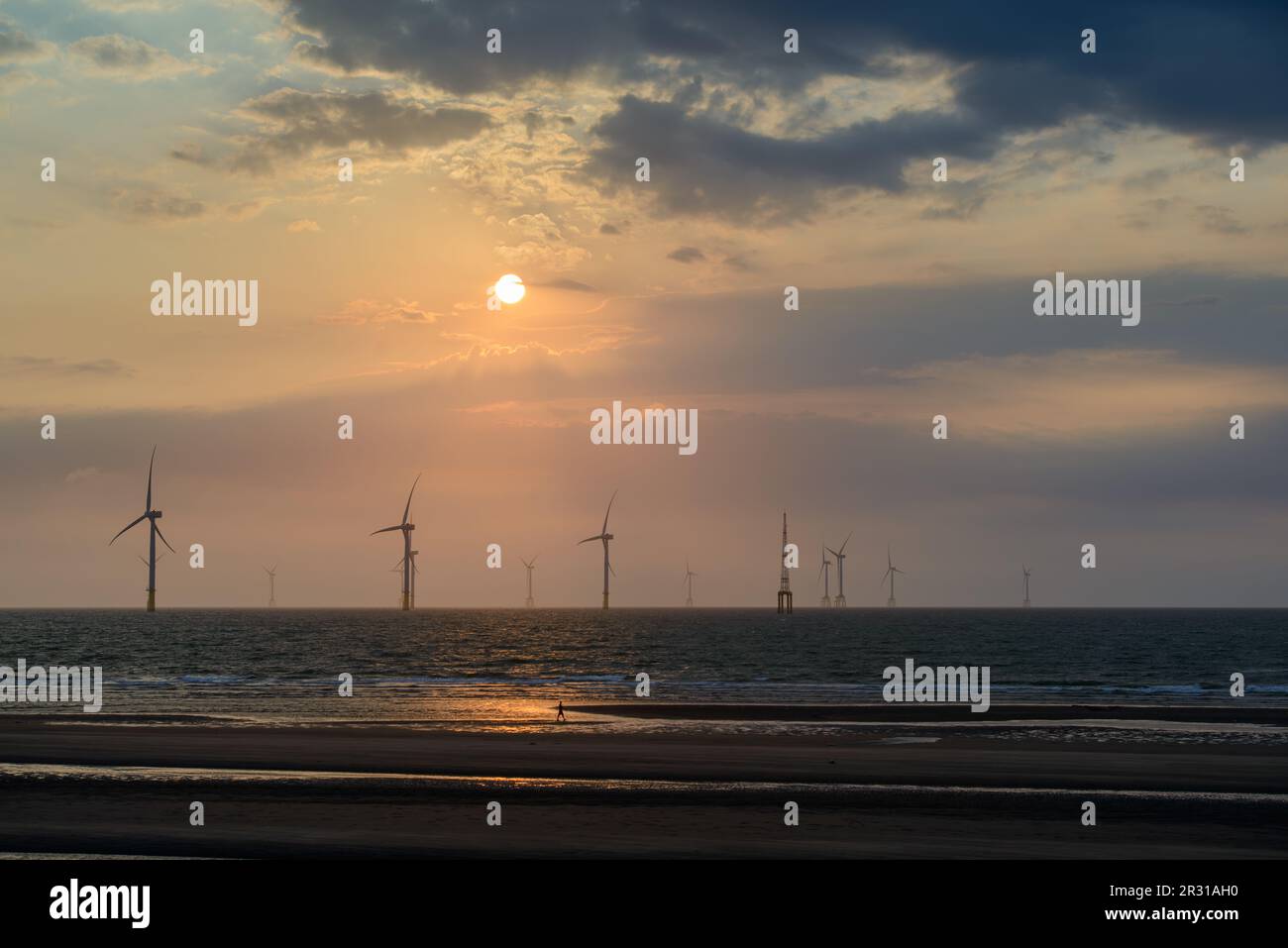 Fans of wind turbines spin over the sparkling sea. Dynamic clouds at ...