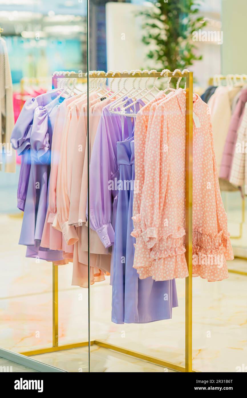 Womens summer clothes hanging on rail. Blurred View through shop window ...