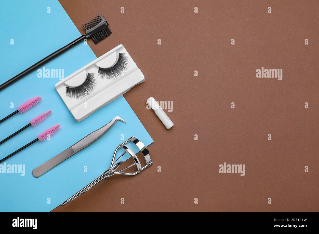 Flat lay composition with fake eyelashes, brushes and tools on brown ...