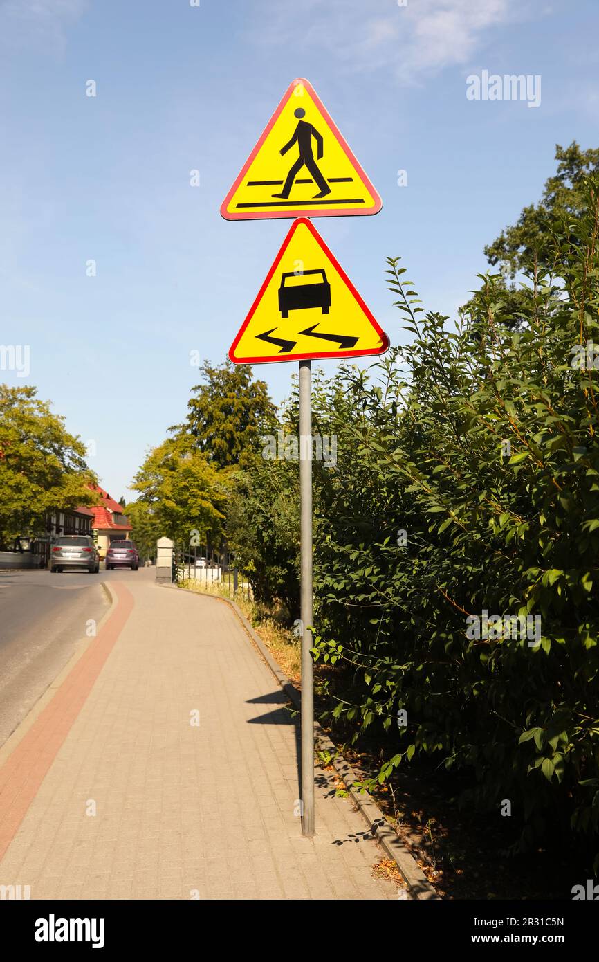 Traffic signs Pedestrian Crossing Ahead and Slippery Road Surface ...
