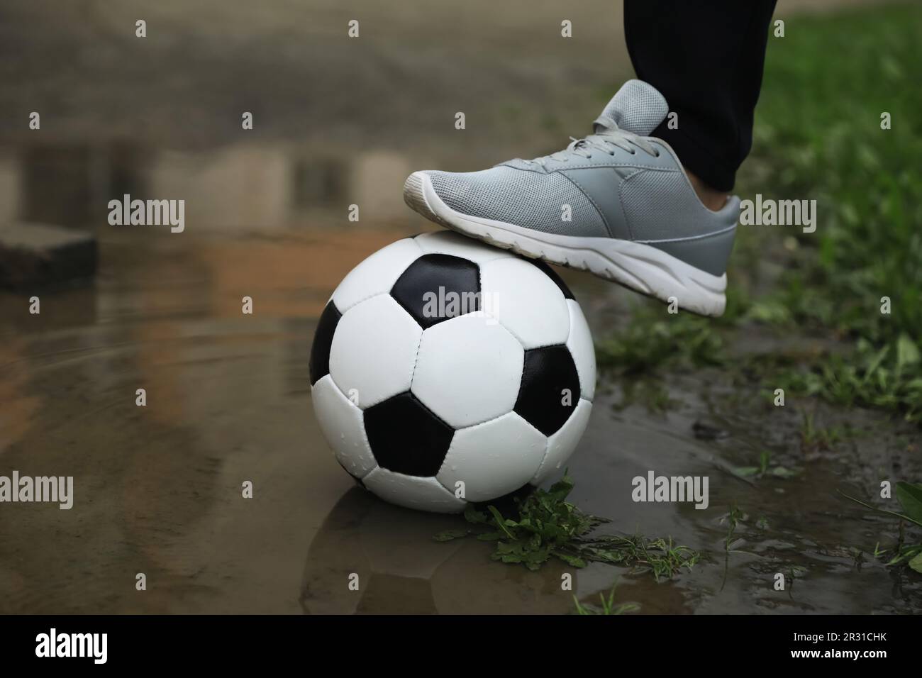 Man with soccer ball in puddle outdoors, closeup Stock Photo - Alamy