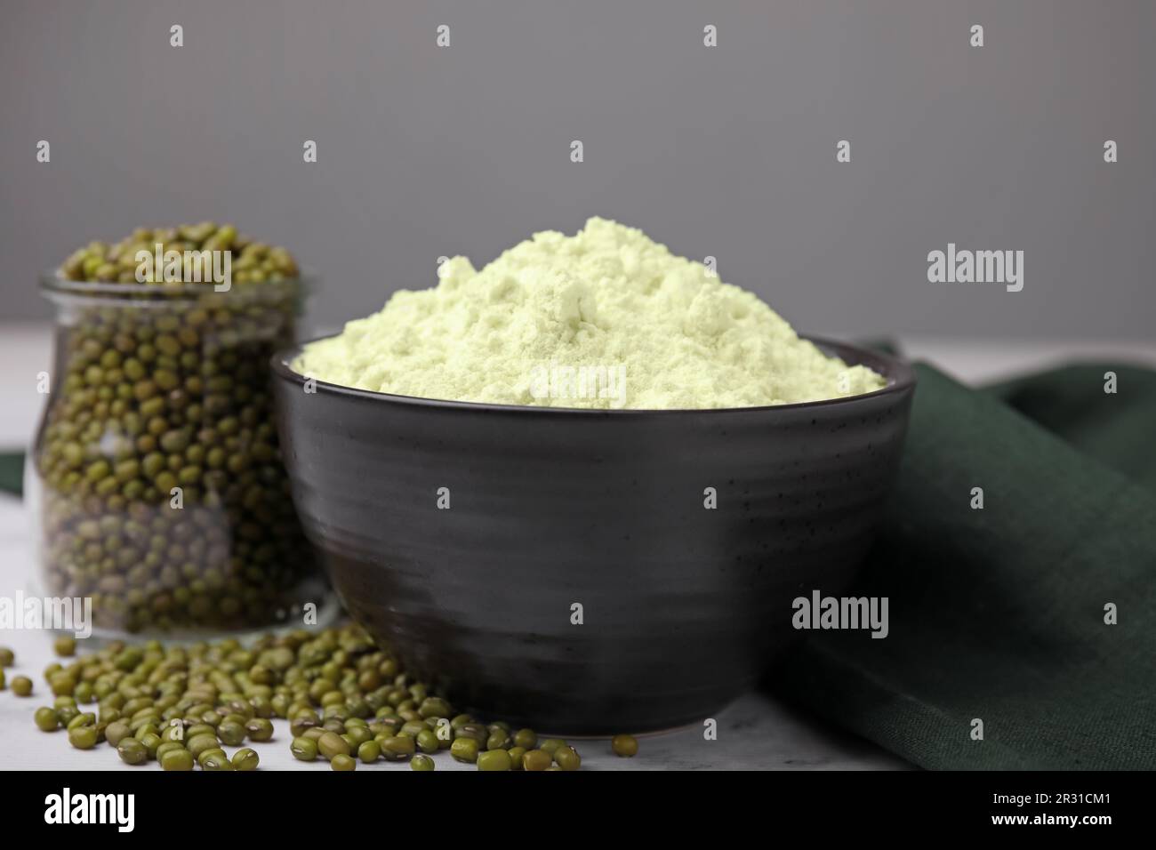 Mung bean flour in bowl and seeds on white marble table Stock Photo - Alamy
