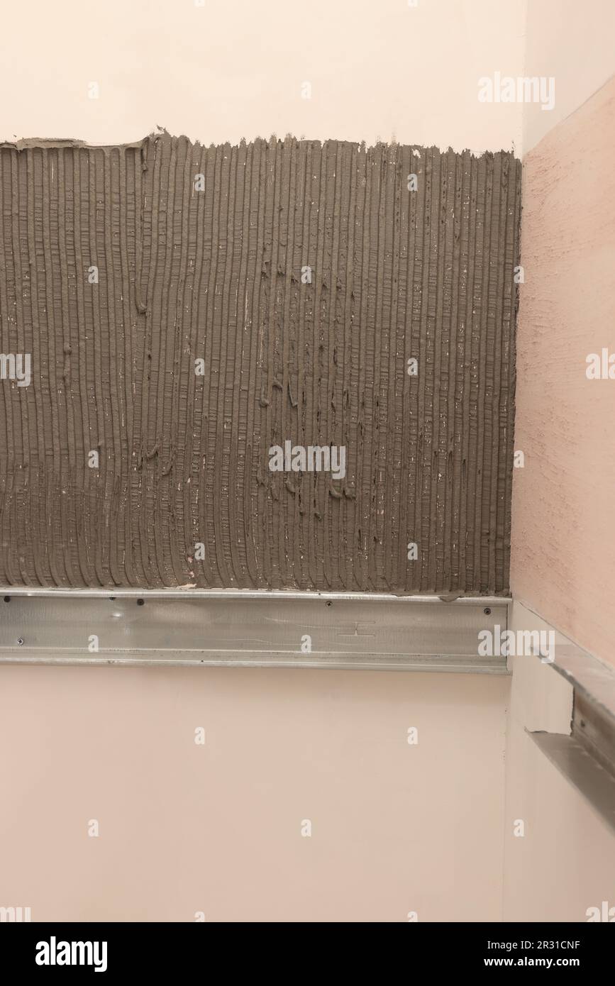 Adhesive mix for installing tile and socket holes on wall, closeup ...