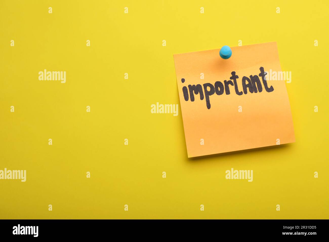Paper note with word Important pinned on yellow background, space for ...