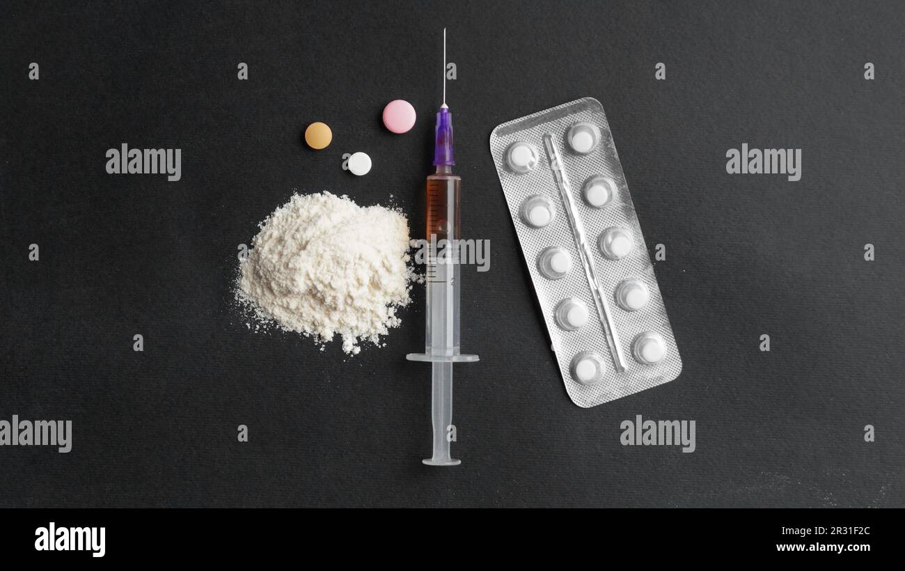 Powder, syringe and pills on black background, flat lay. Hard drugs ...