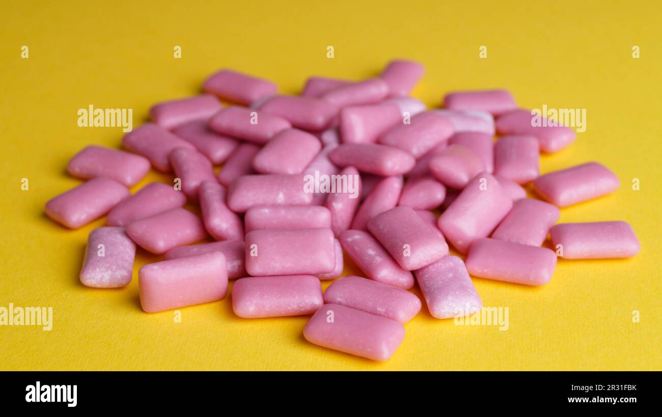 Pile of sweet chewing gums on yellow background Stock Photo - Alamy