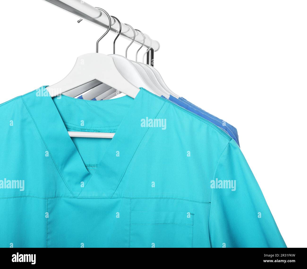 Turquoise and light blue medical uniforms on rack against white ...